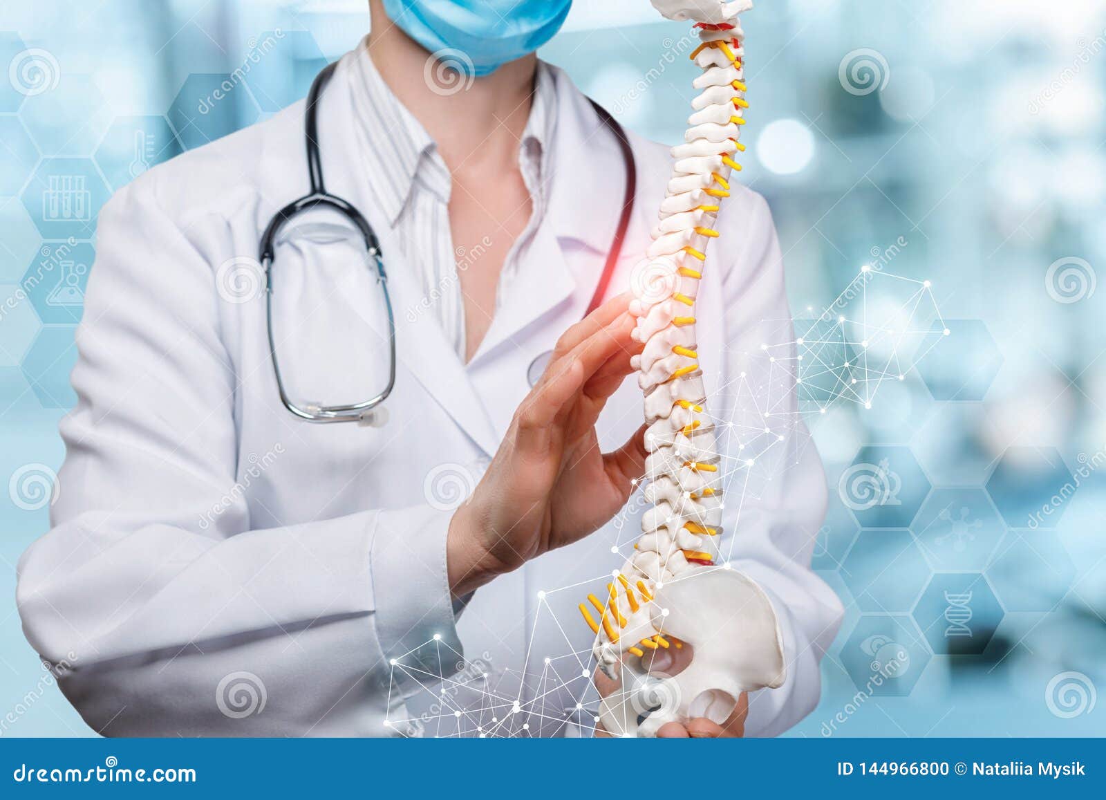 A Physiotherapist with a Stethoscope Examining a Spine Model Stock ...