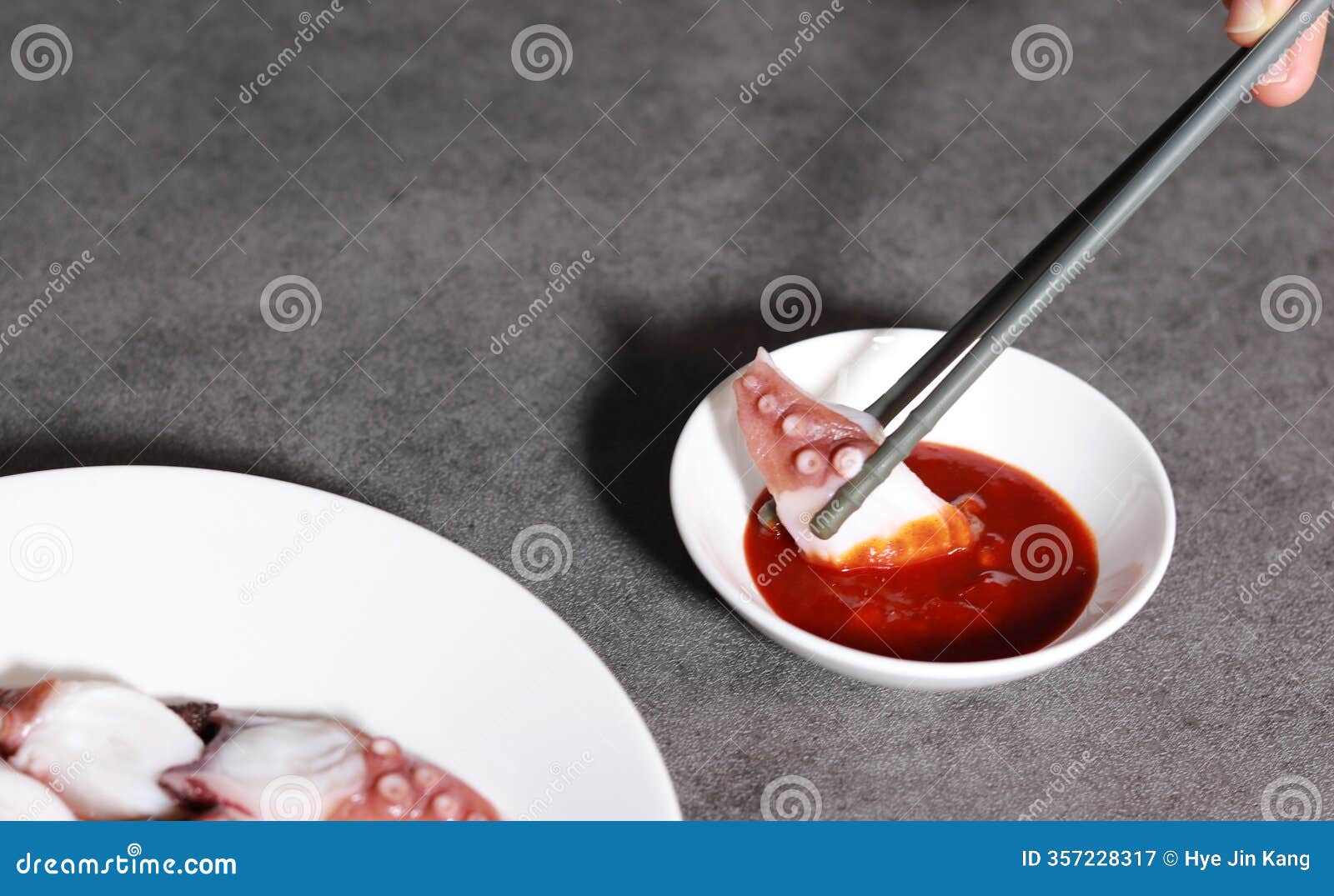 Pick Up the Sliced Octopus with Chopsticks and Dip it in Red Pepper ...