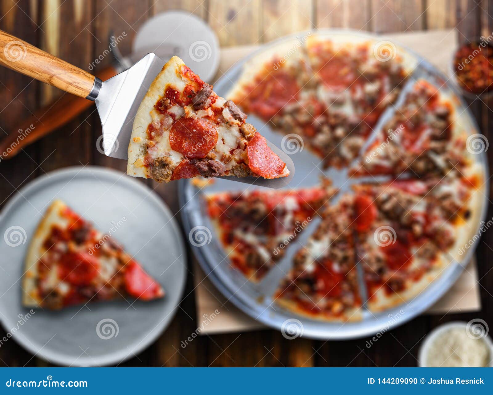 Picking Up Slice of Meaty Sausage and Pepperoni Pizza Top Down View ...