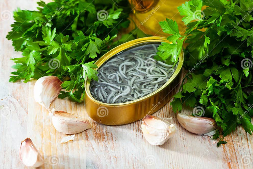 Pickled Eels in Open Tin Can with Garlic at Table Stock Photo - Image ...