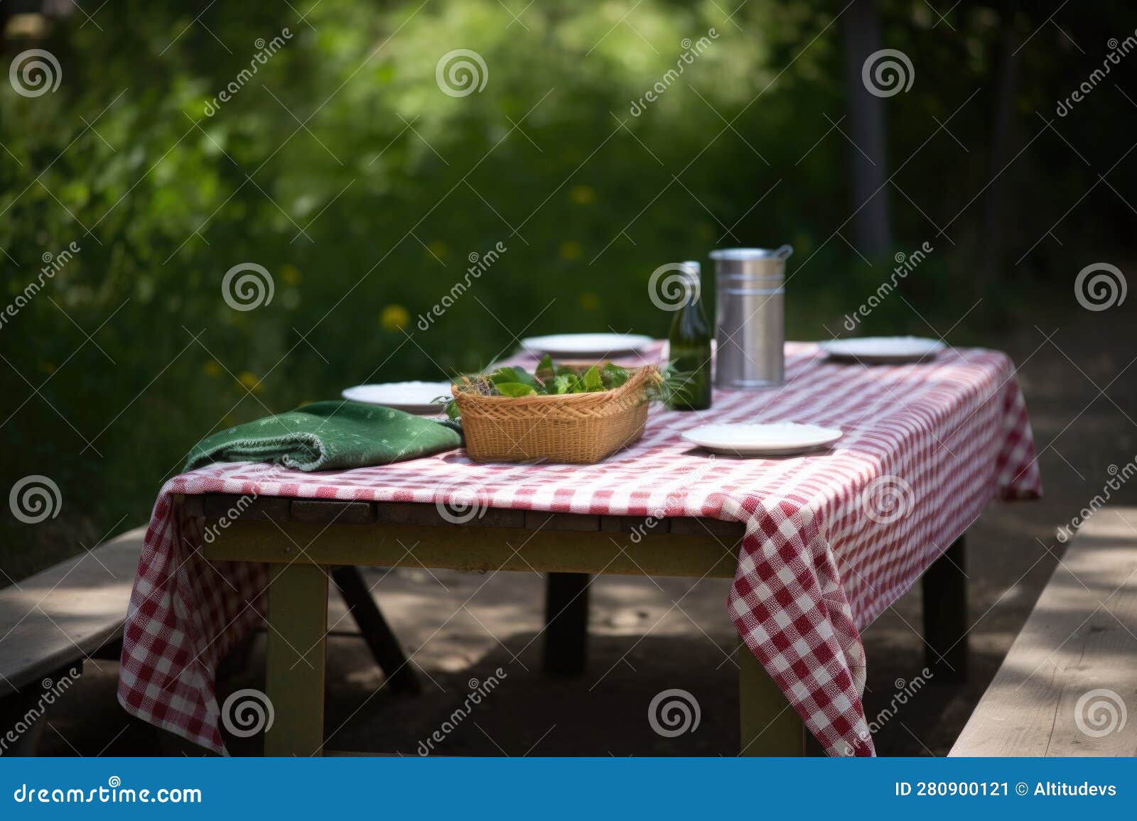 A Picnic Table with a Checkered Cloth and Place Settings for Two Stock ...