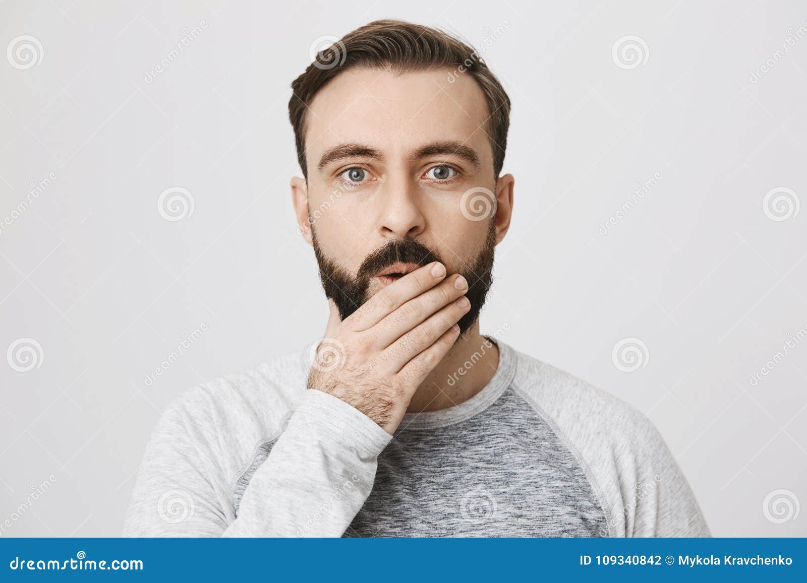 Picture Of Handsome Man With A Beard Expressing Surprise Covering His