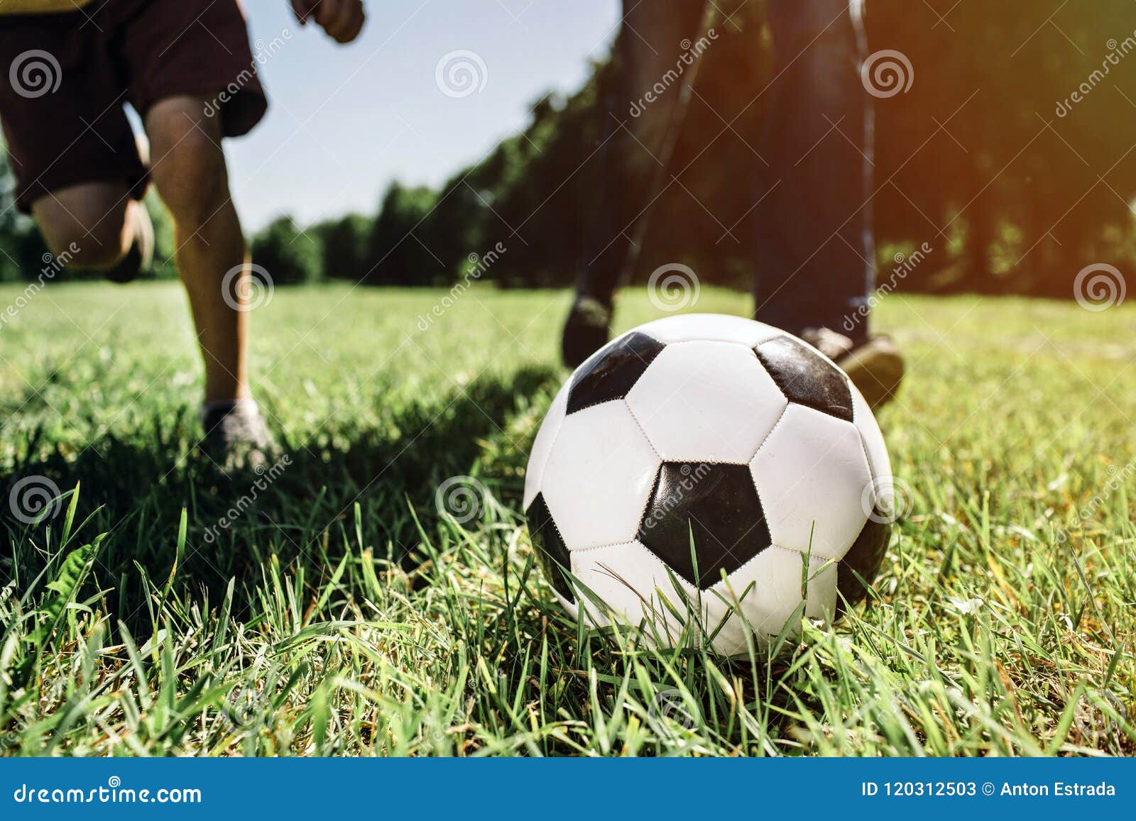 A Picture Of Legs Of Two People Playing Football Game They Are Playing On Green And Juicy Grass