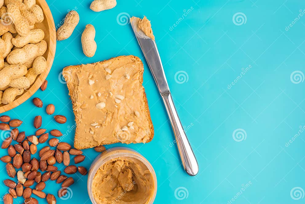 A Piece of Bread Smeared with Peanut Butter, a Jar of Nut Paste on a ...