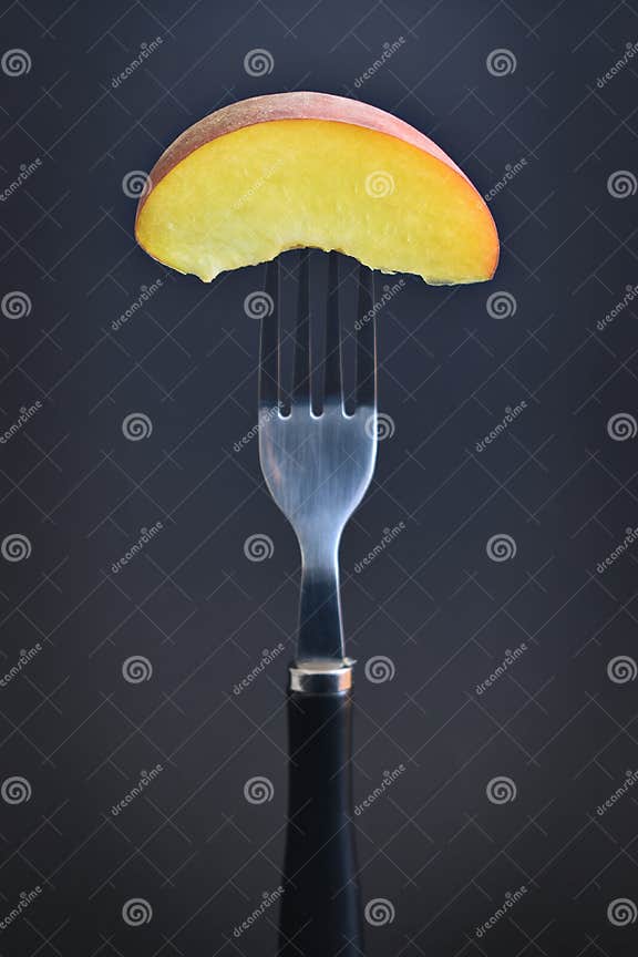 Piece of peach on a fork stock photo. Image of leaf - 107657054