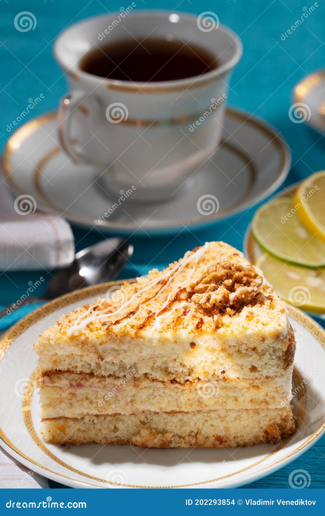 A Piece of Sponge Cake on a White Plate with a Cup of Tea Stock Photo ...