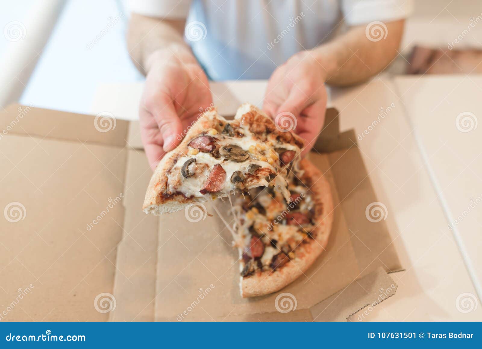 Pieces of Appetizing Pizza in Men`s Hands. a Man Eats a Hot Pizza from ... Pieces of Appetizing Pizza in Men`s Hands. a Man Eats a Hot Pizza from ...