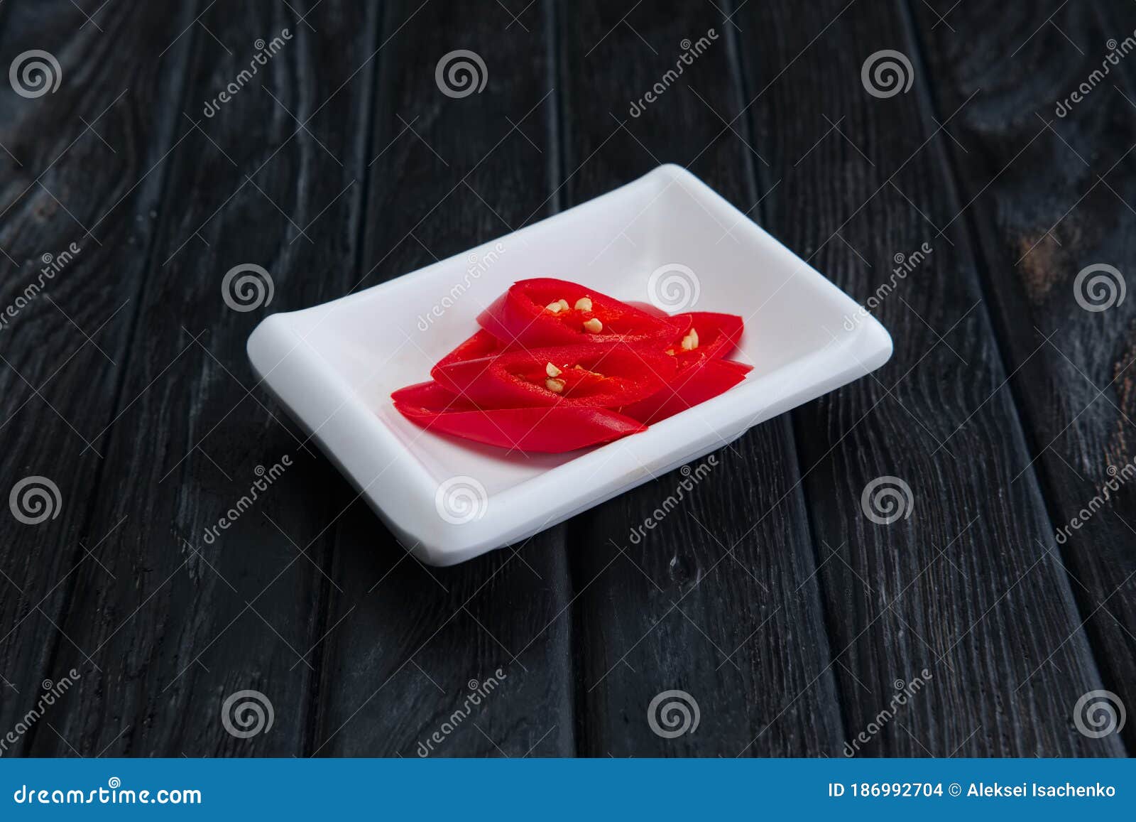 Pieces of Chilli in Plate on Dark Wooden Background Stock Photo - Image ...