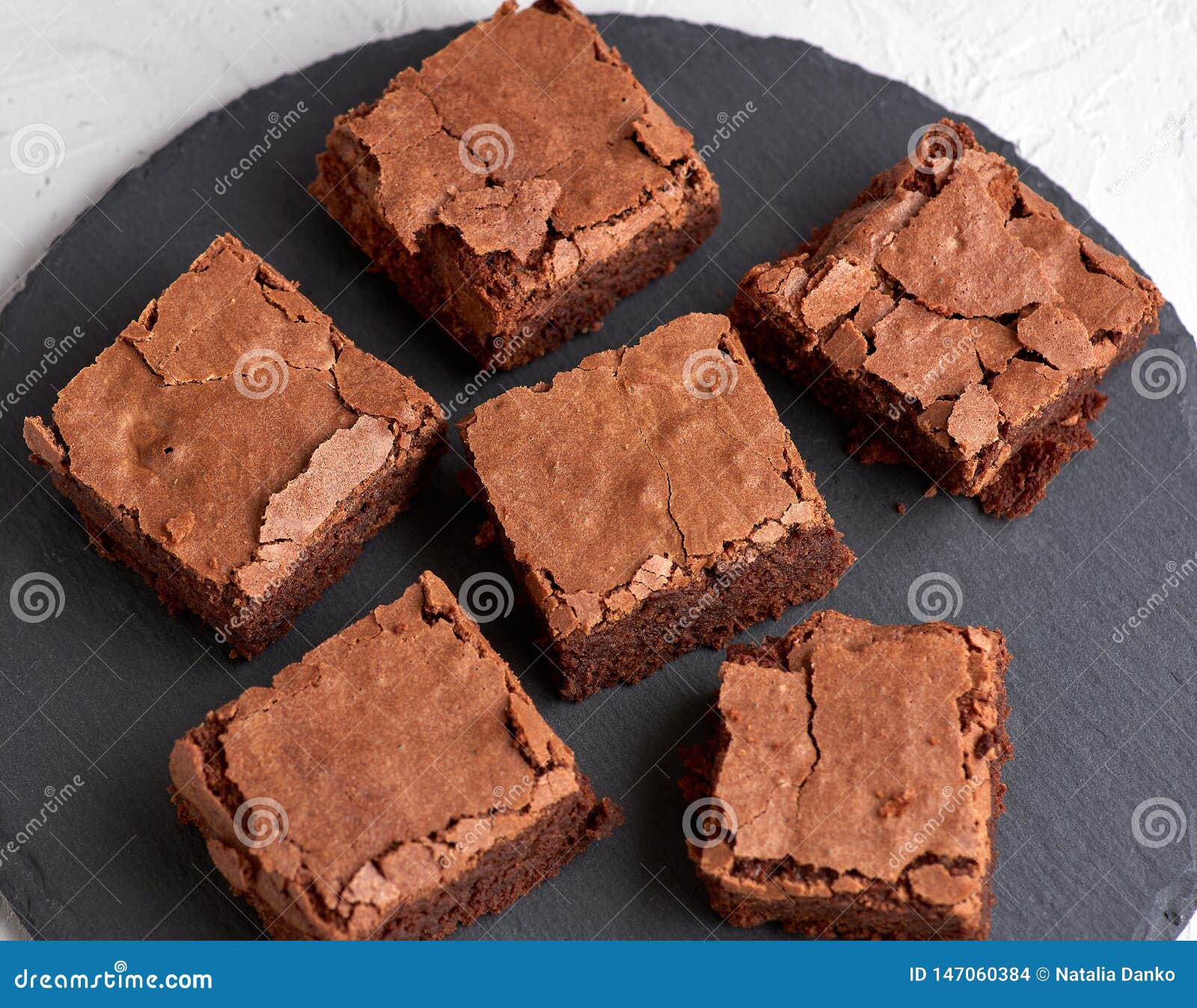 Pieces of Chocolate Brownie on a Black Round Graphite Plate Stock Photo ...