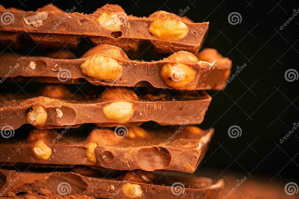 Pieces of Chocolate with Nuts Stack on a Black Background.Broken ...