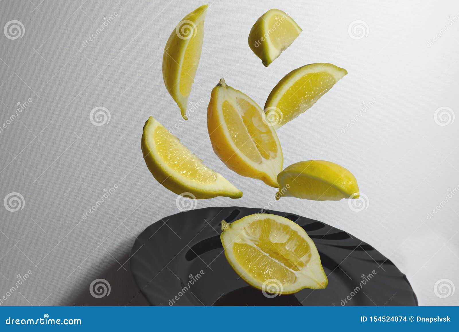 Pieces of Lemon Flying in the Air on the Black Plate Stock Photo ...
