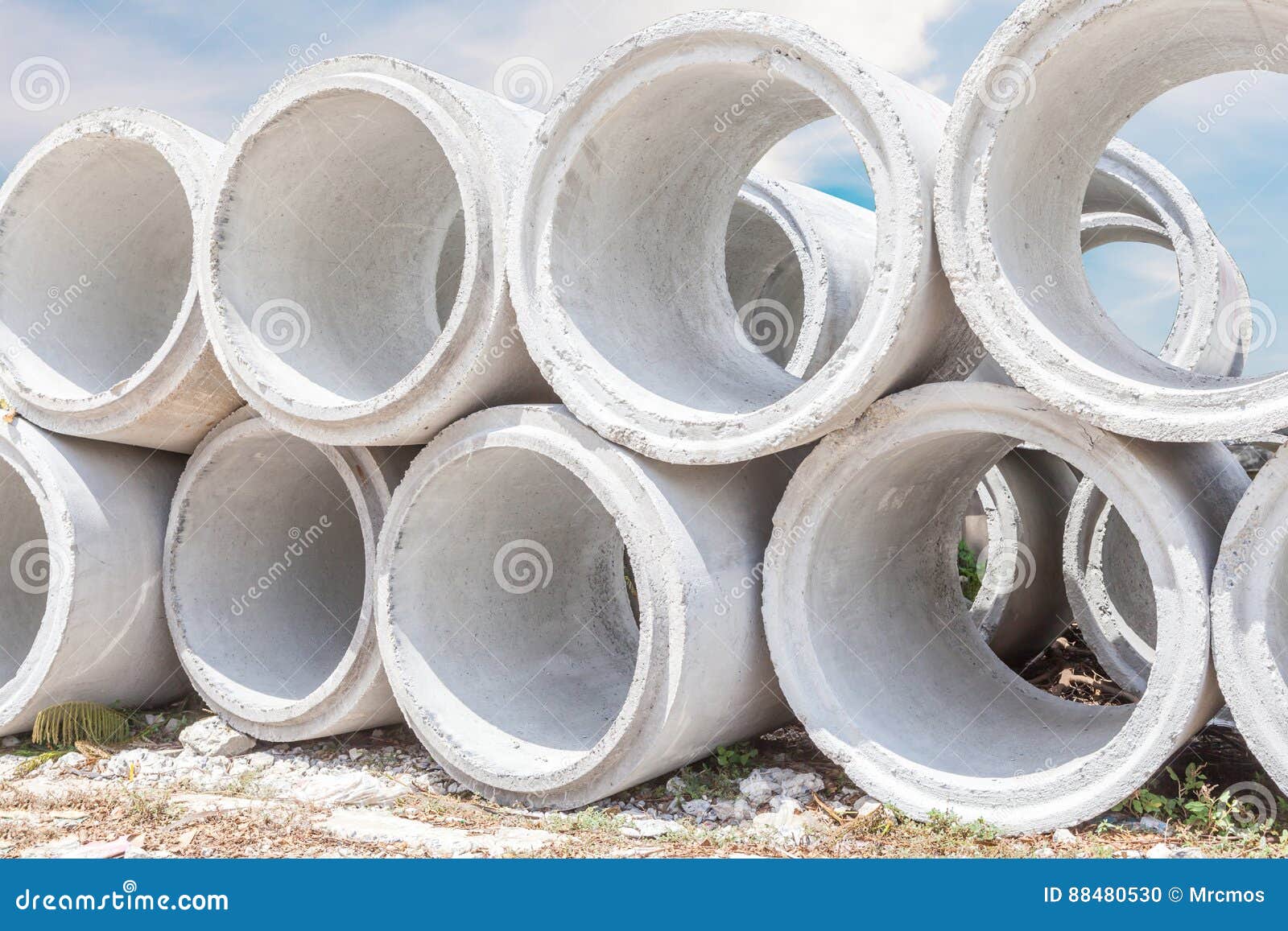 Pile Of Big Concrete Drainage Pipes With Construction Site Background ...