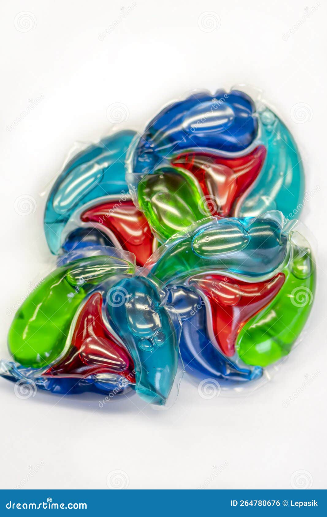 A Pile of Four-color Laundry Detergent Capsules on a Light Background ...