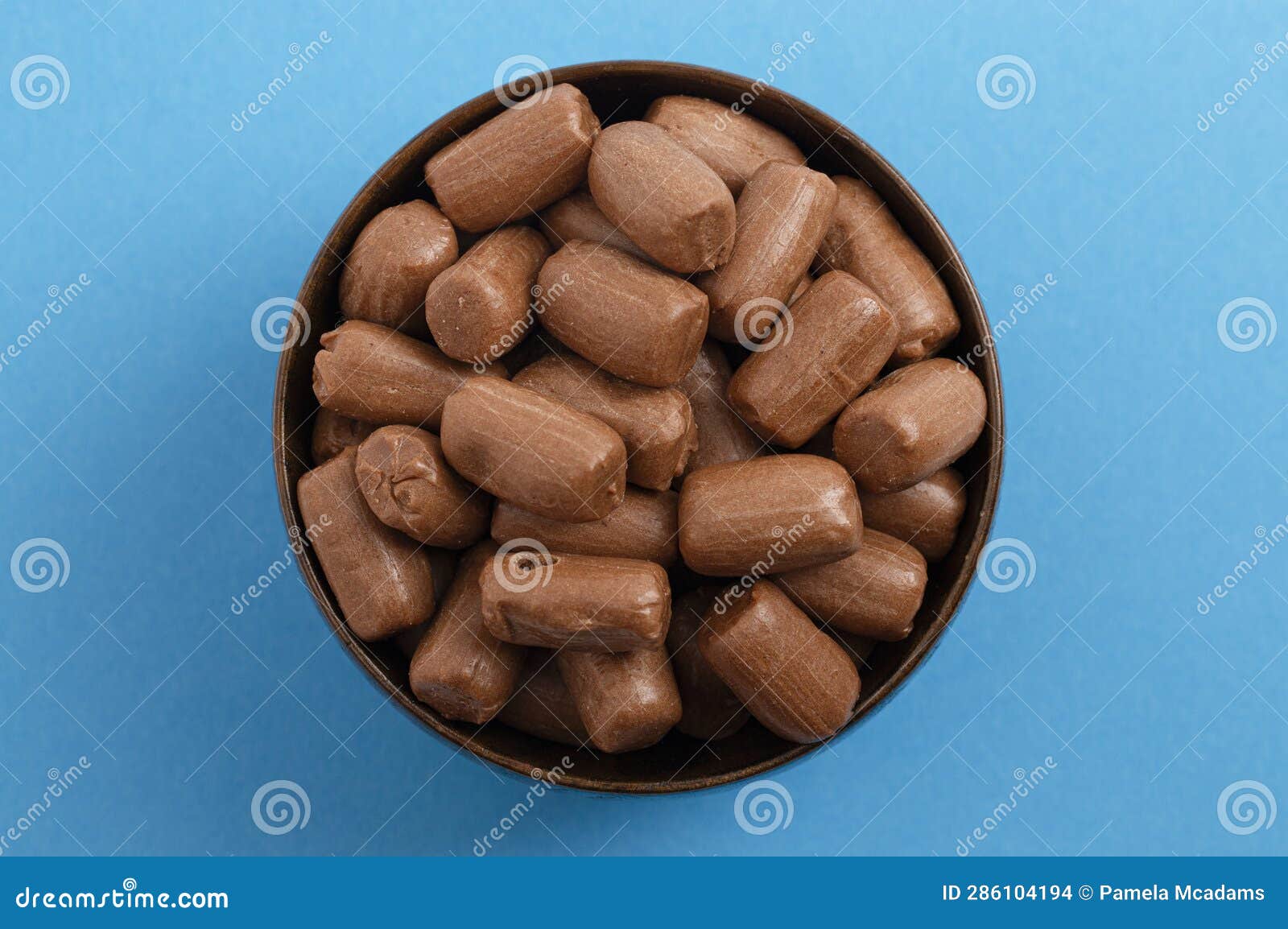 A Pile of Freeze Dried Chocolate Candy Rolls Isolated on a Blue ...