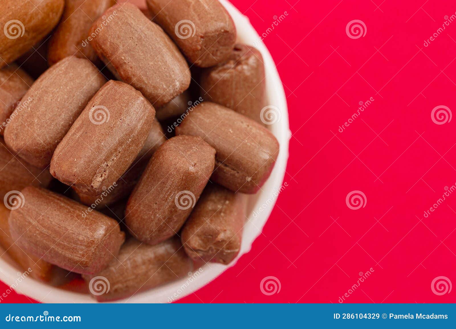 Pile of Freeze Dried Chocolate Candy Rolls Isolated on a Red Background ...