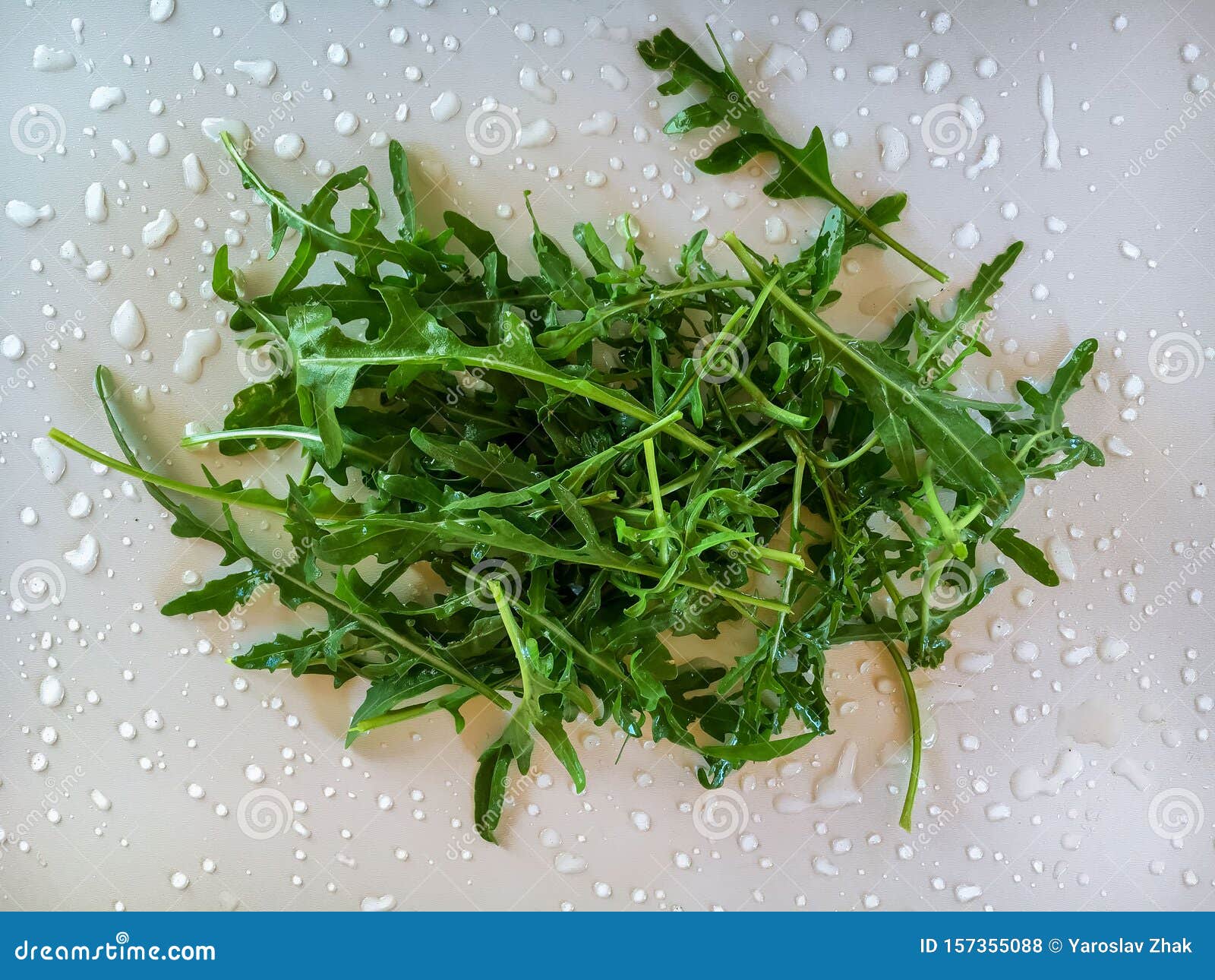 A Pile of Fresh Rocket Leaves on a White Background with Drops of Water ...