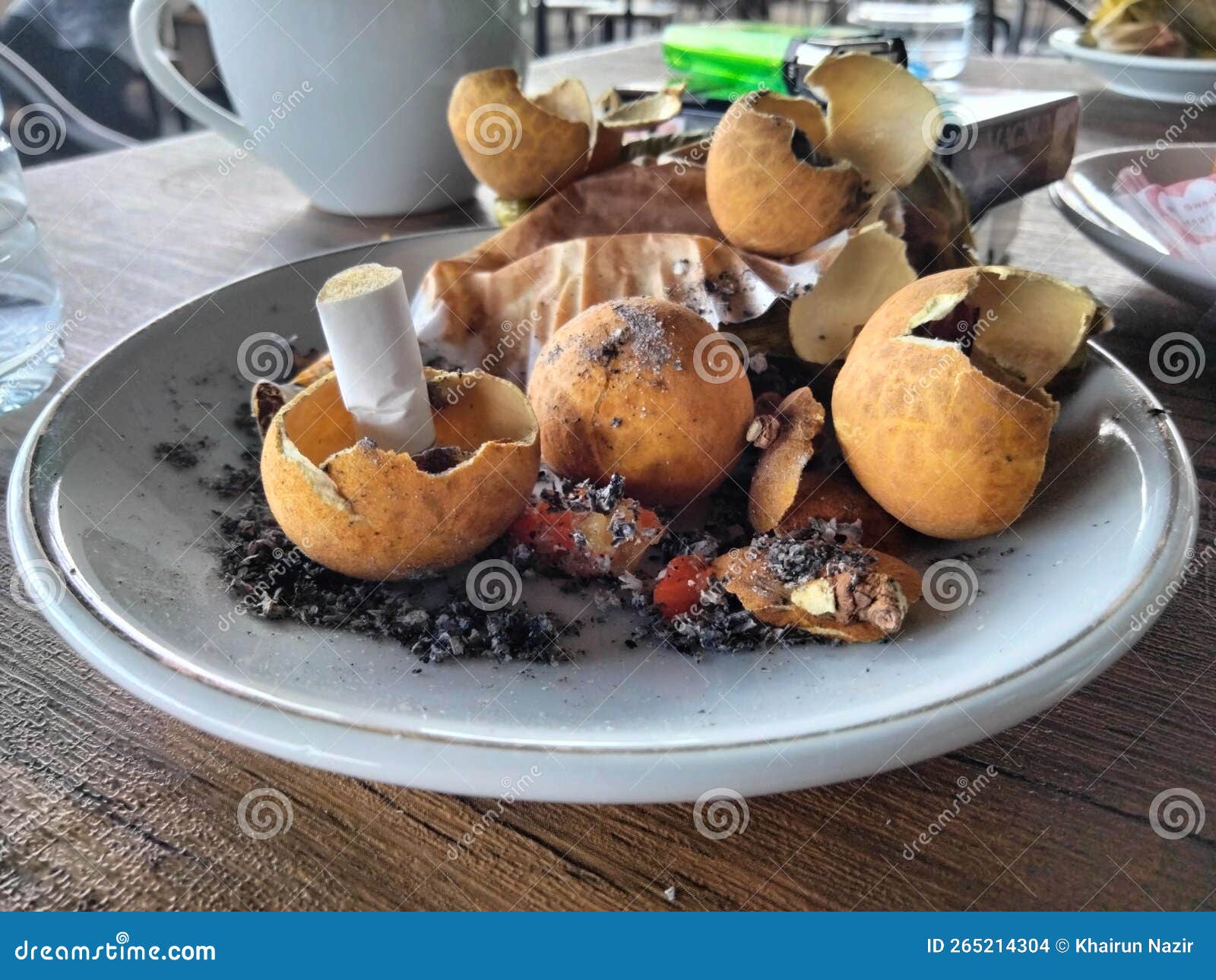 Pile of Fruit Peels and Cigarette Butts on a Small White Plate Stock ...