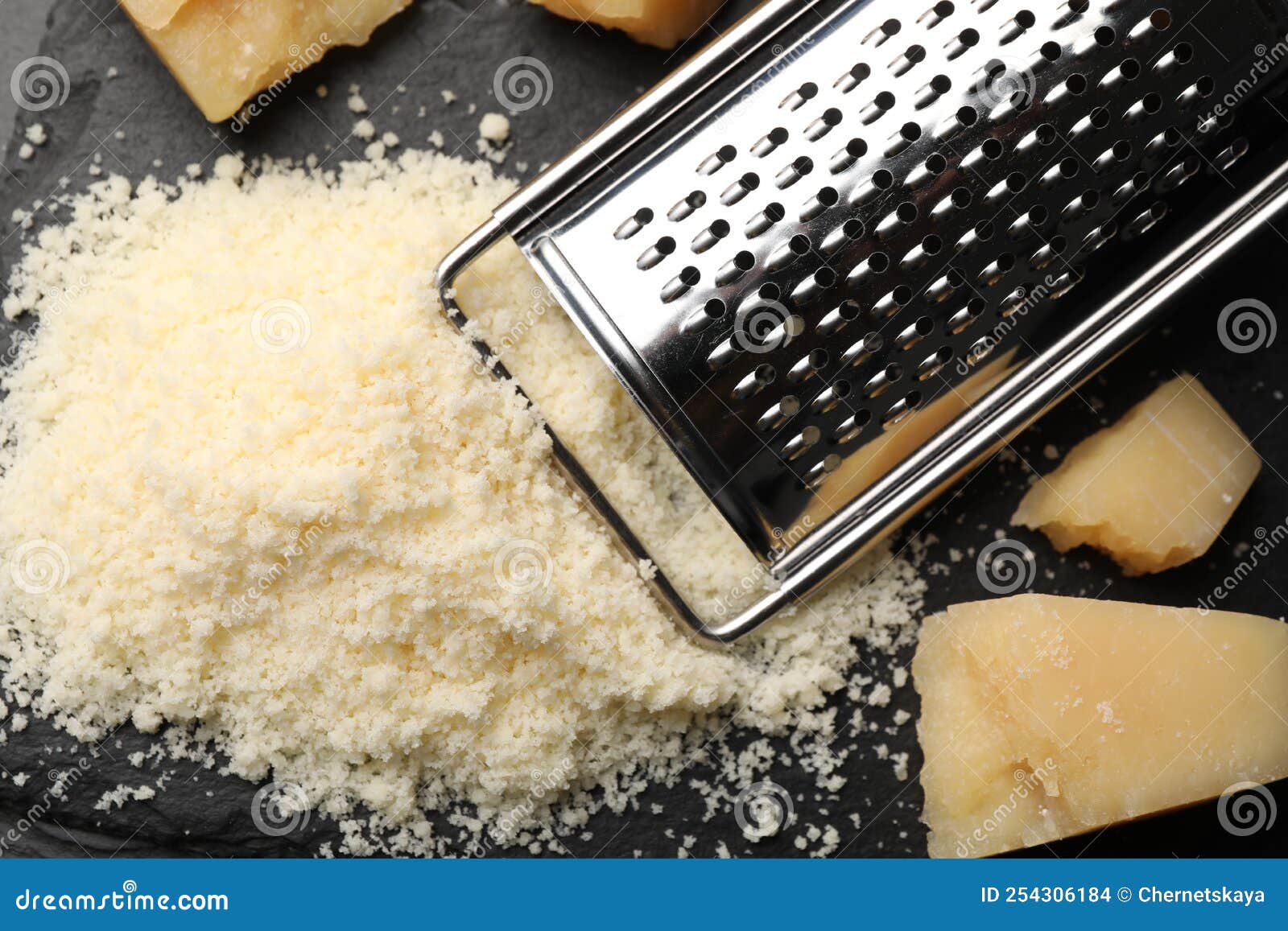 Pile of Grated Parmesan Cheese and Grater on Black Table, Flat Lay ...
