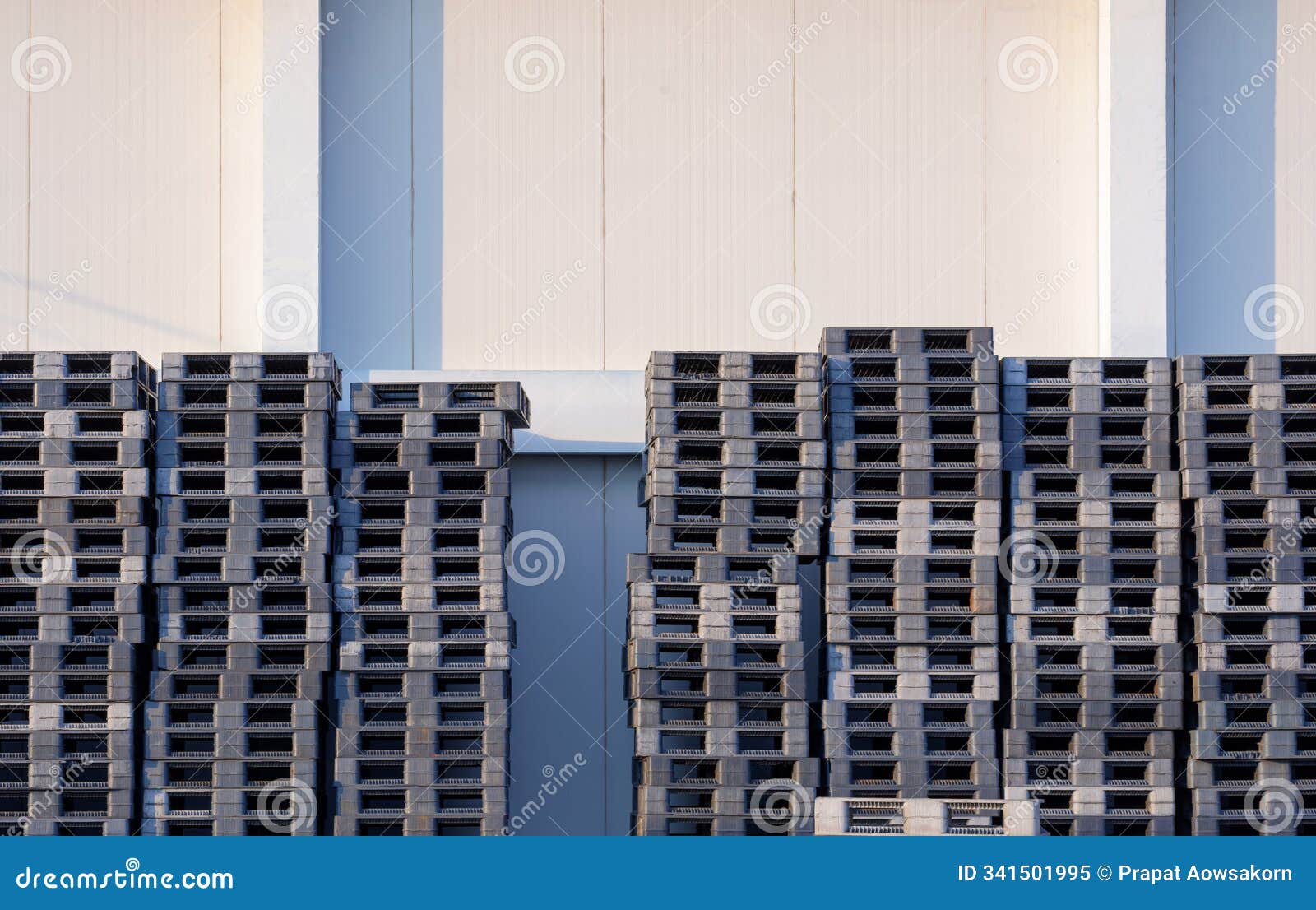 Pile of Plastic Pallets Stacked in Front of White Wall of Industrial ...