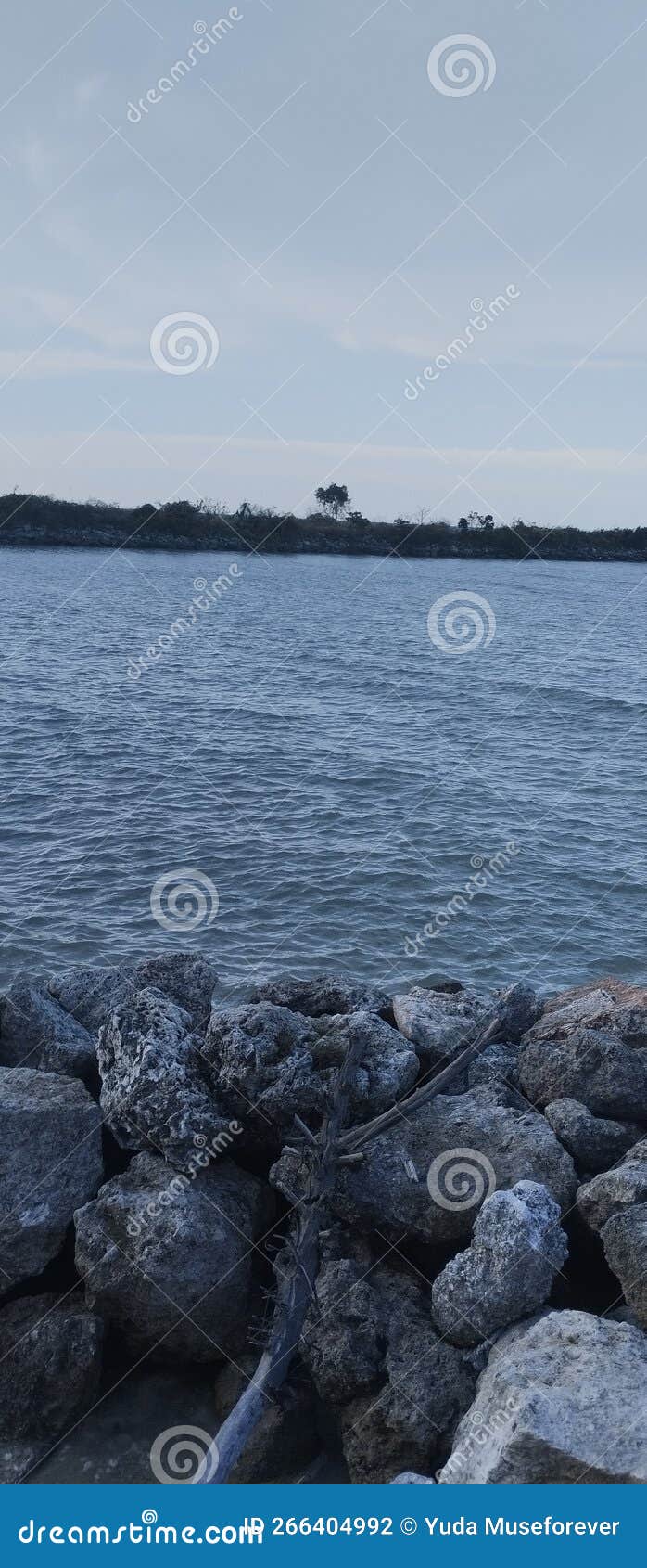 A Pile of Rocks on the Edge of the Ocean in the Late Afternoon with a ...