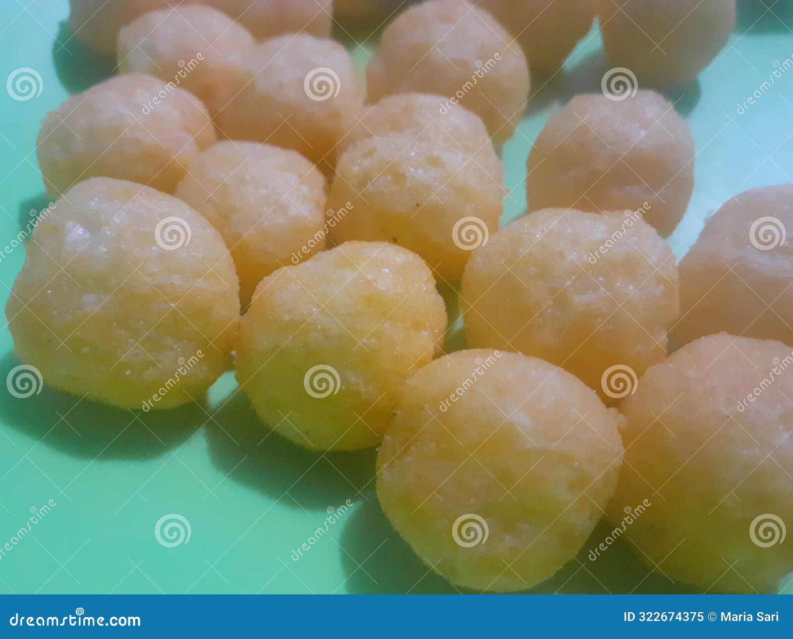 A Pile of Round, Cheese-flavored Ciki on a Green Plastic Plate at Night ...