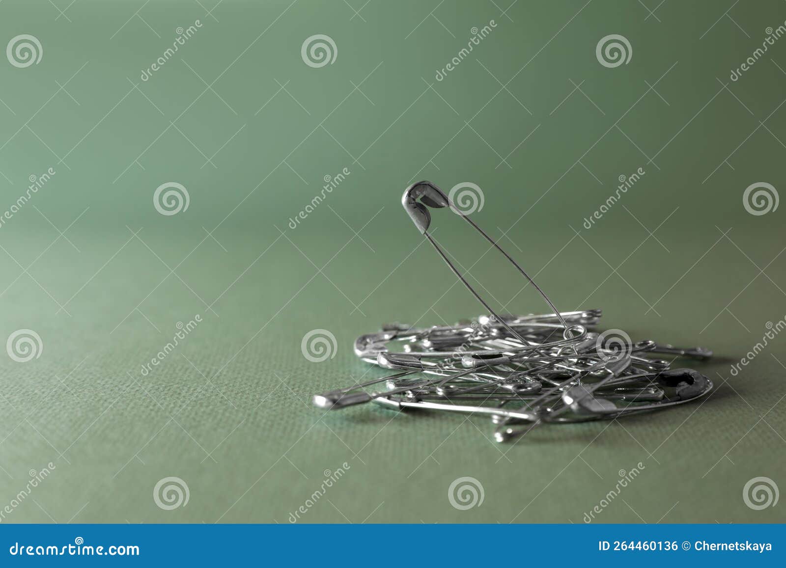 Pile of Safety Pins on Green Background, Space for Text Stock Photo ...