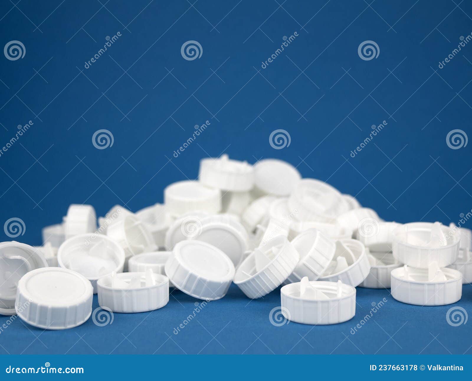 Pile of White Plastic Caps on the Blue Background. Closures Made from ...