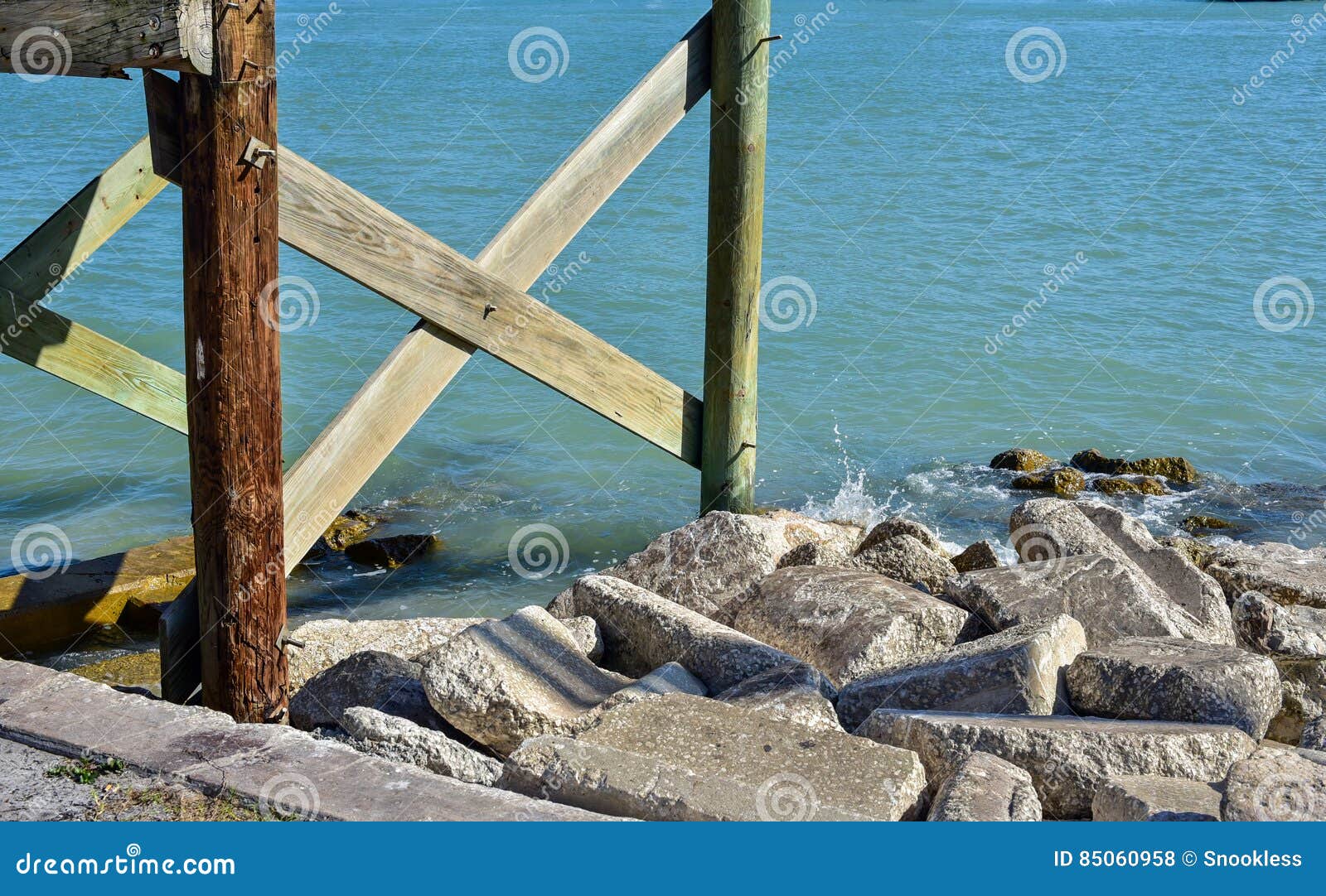 Pilings from Pier and Rocks Stock Photo - Image of pier, blue: 85060958