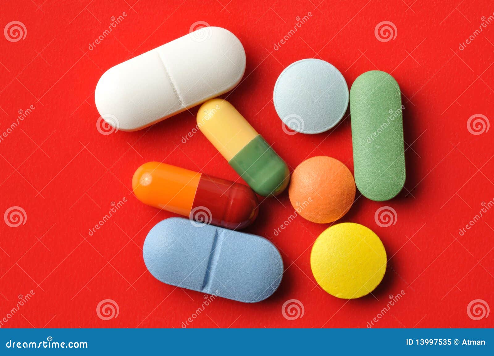 Pillole su colore rosso immagine stock. Immagine di capsule - 13997535