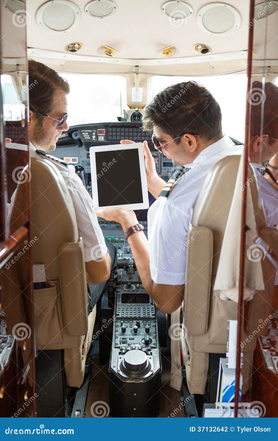 Pilot Showing Digital Tablet To Copilot in Cockpit Stock Photo - Image ...