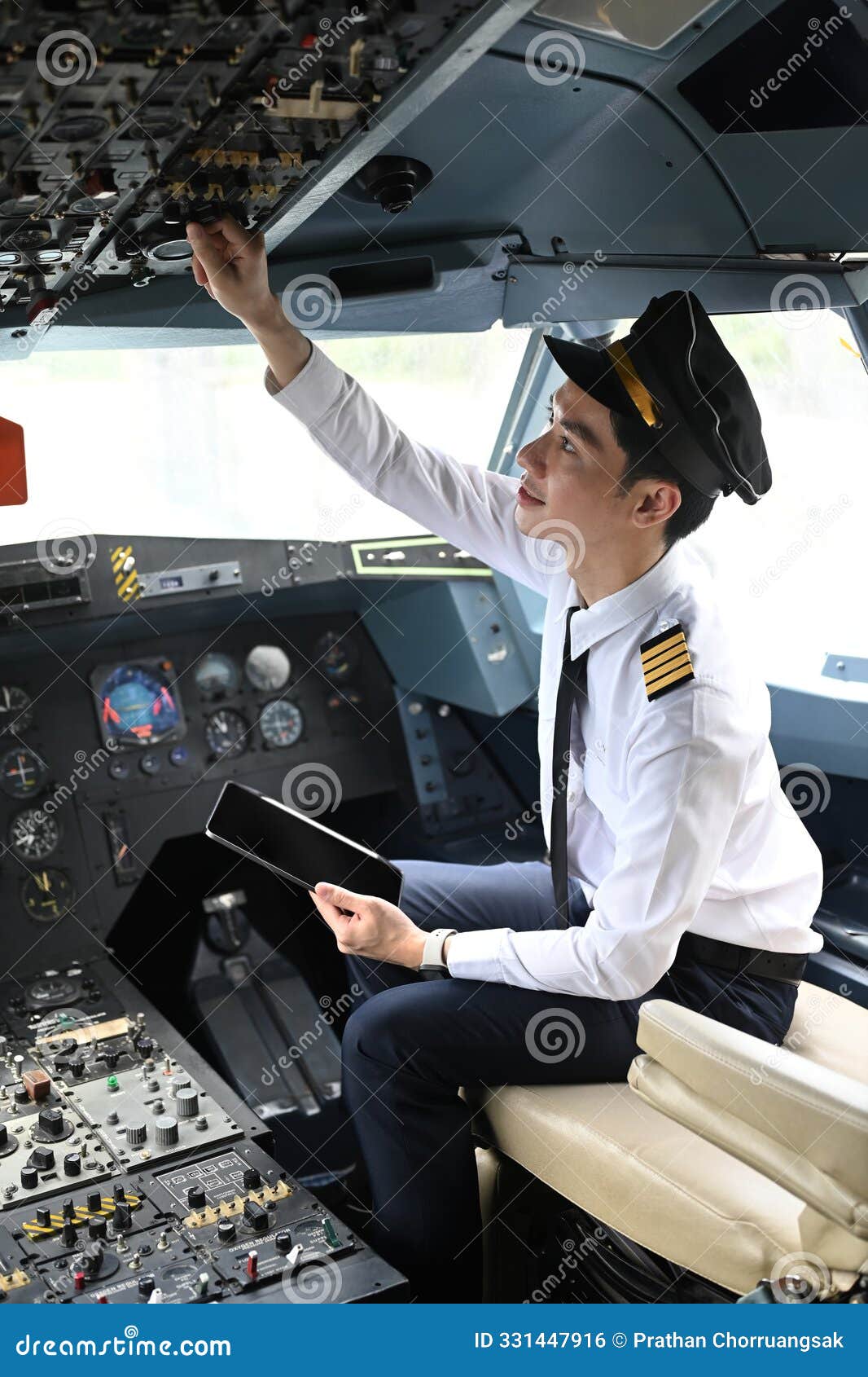 Pilot Sitting in the Cockpit of an Airplane and Adjusting Controls on ...