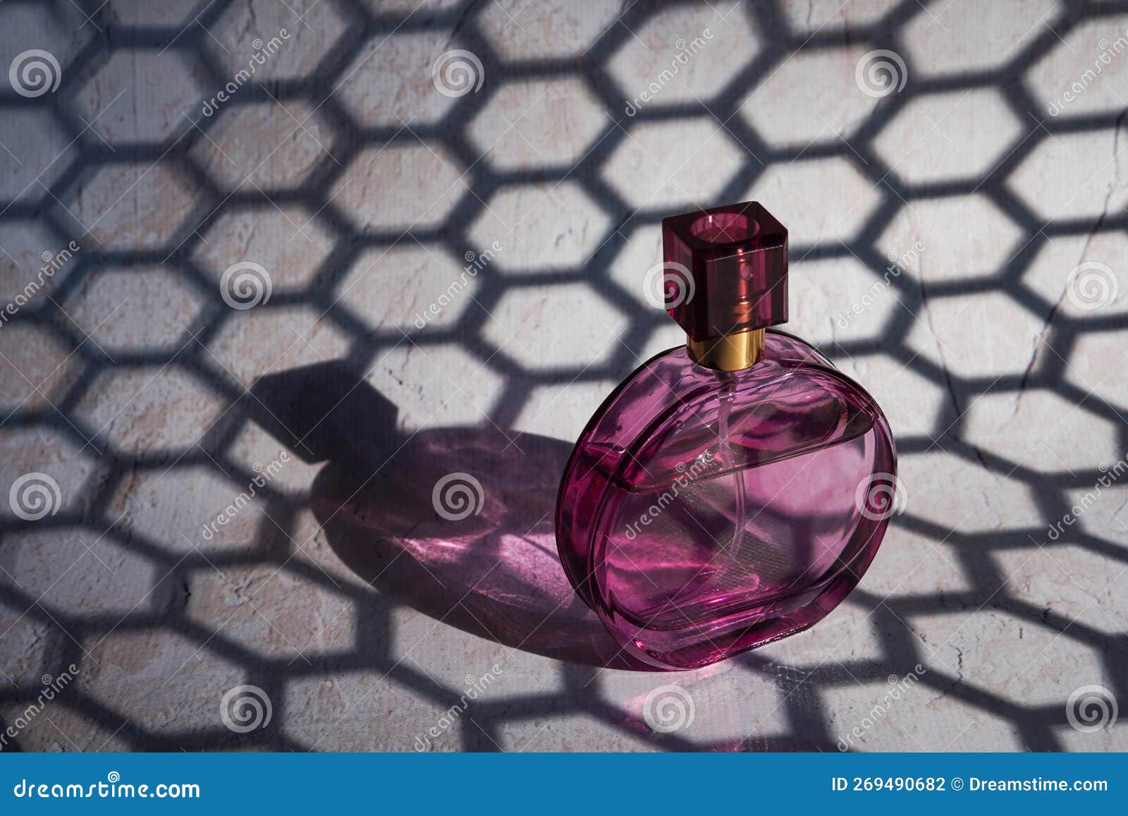 Pink Perfume Bottle with Reflections and Contrasting Shadows Stock ...