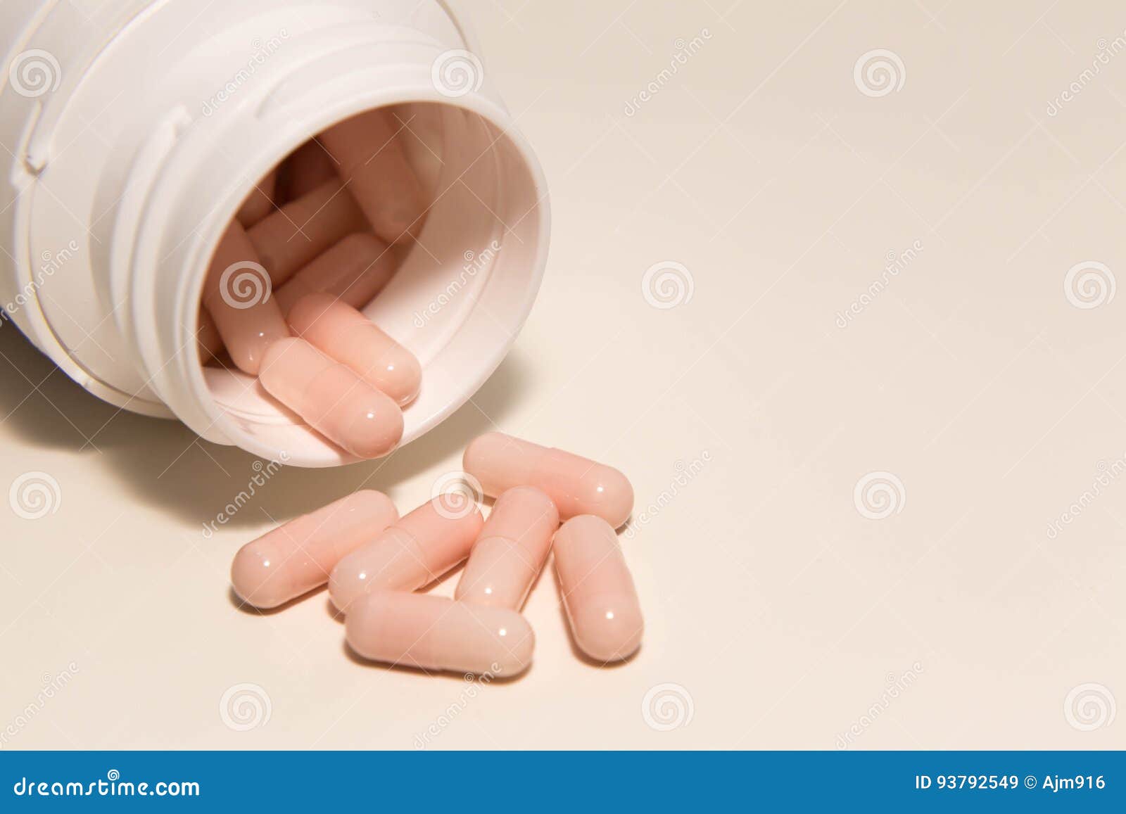 Pink Pills Spilling Out of a White Pill Bottle on a White Background ...