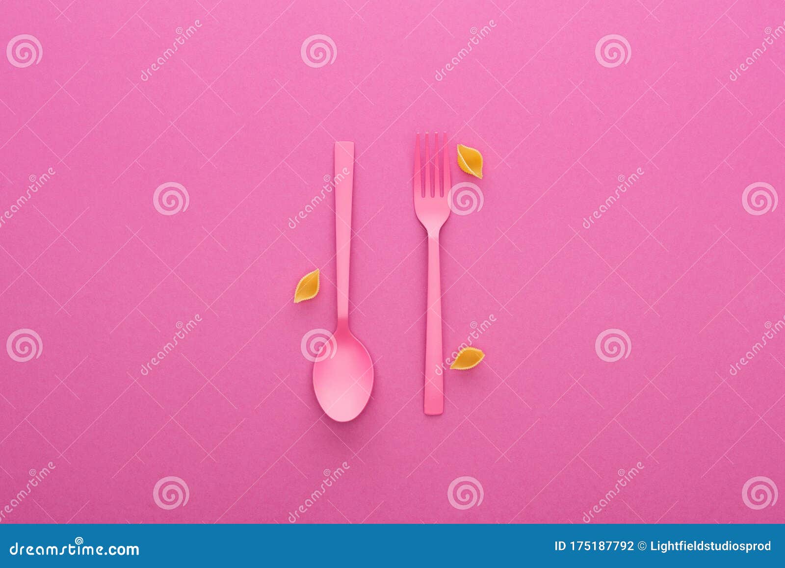 Pink Plastic Fork and Spoon Upside Down and Uncooked Shells Macaroni ...