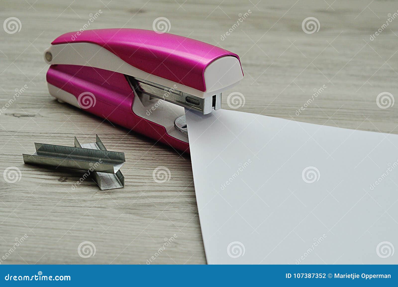 A Pink Stapler with Papers and a Pile of Staplers Stock Photo - Image ...