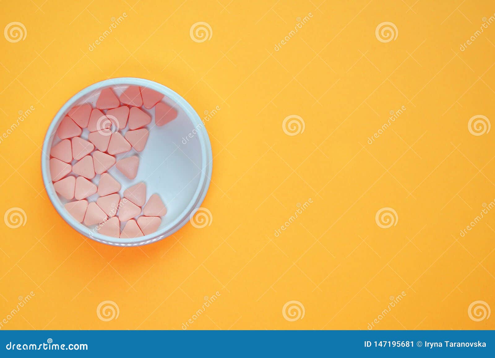 Pink Triangular Unusual Pills in a White Round Box on Yellow Background ...