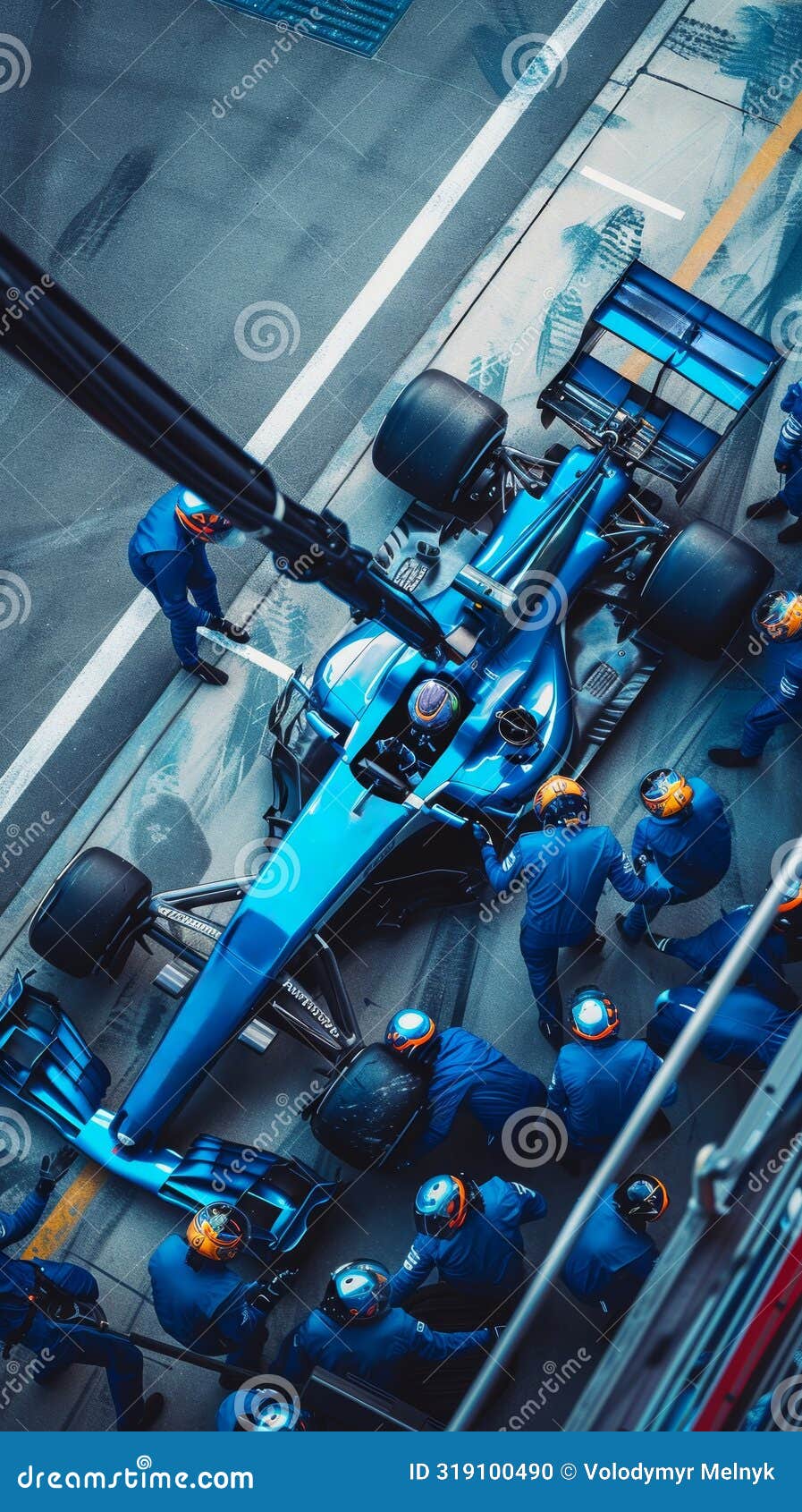 Pit Crew Precision. Team in Blue Suits Works Meticulously on Race Car ...