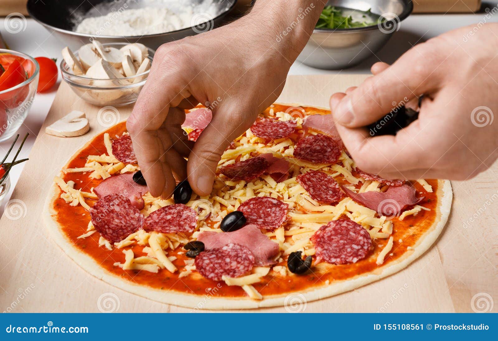 Pizzaiolo Making Pizza, Adding Black Olives and Decorating it Stock ...