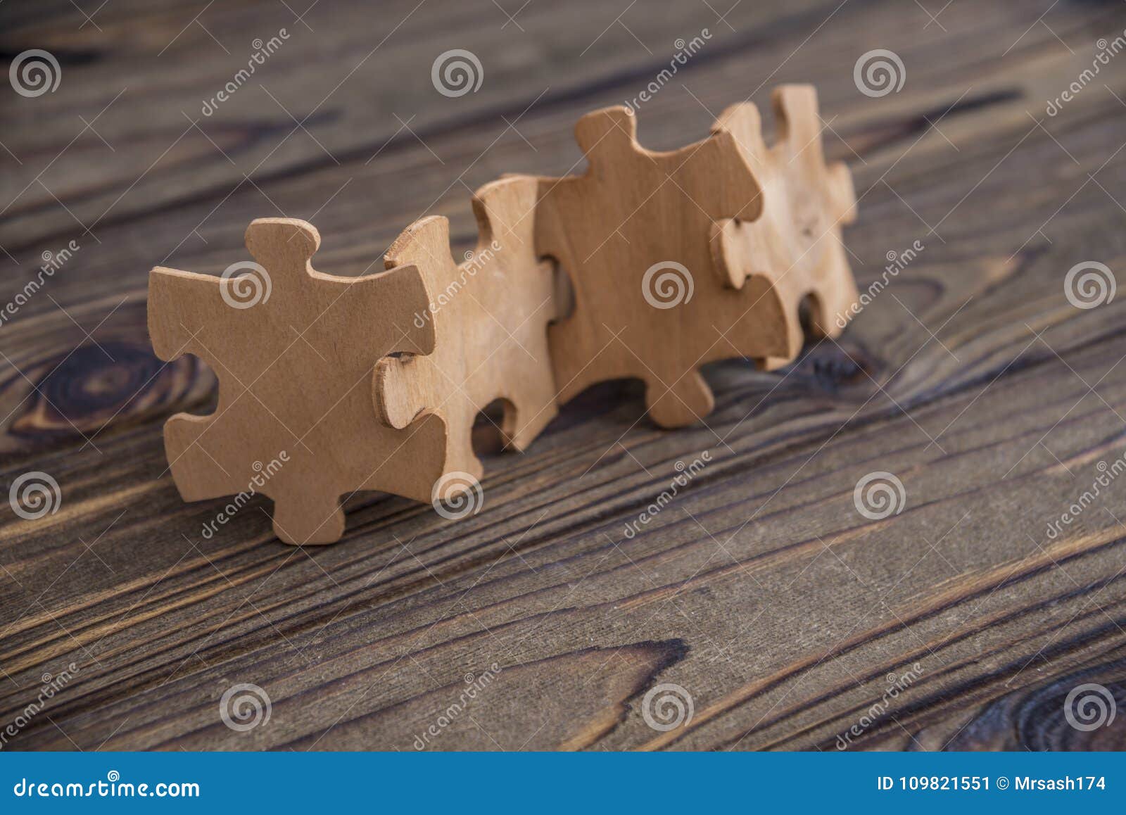 Placing a Piece of the Puzzle in a Row on a Textured Rustic Wooden ...