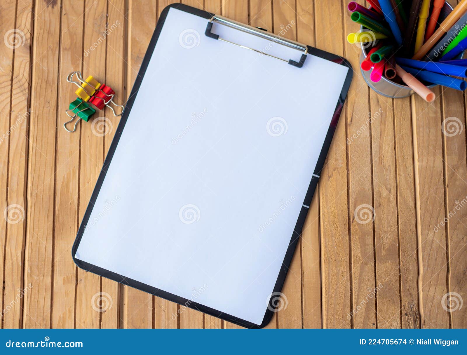 Plain Office Clipboard with Stack of Pens in a Holder on Top of a Table ...