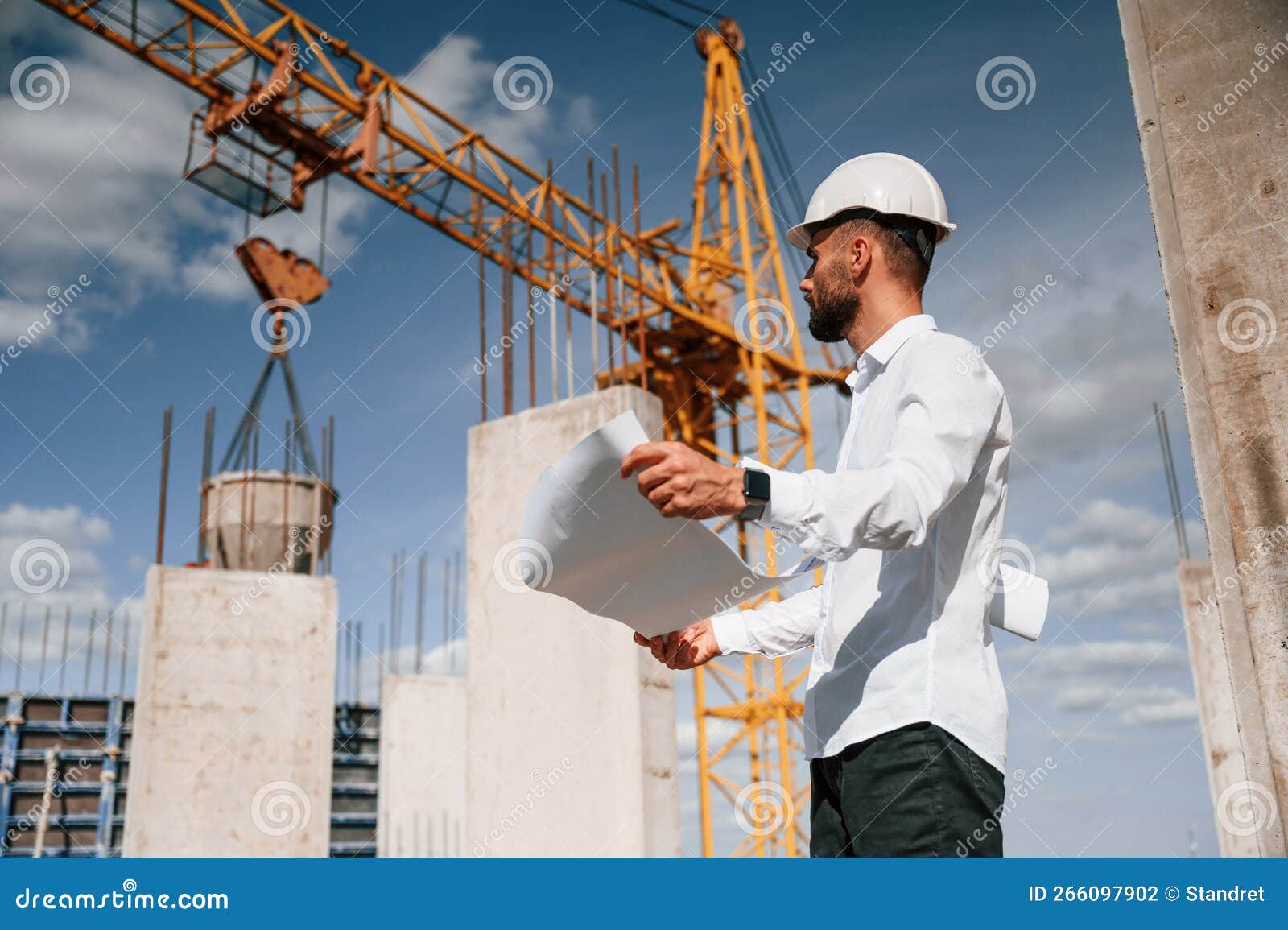 With Plan in Hands. Man in Uniform is Working on the Construction Site ...