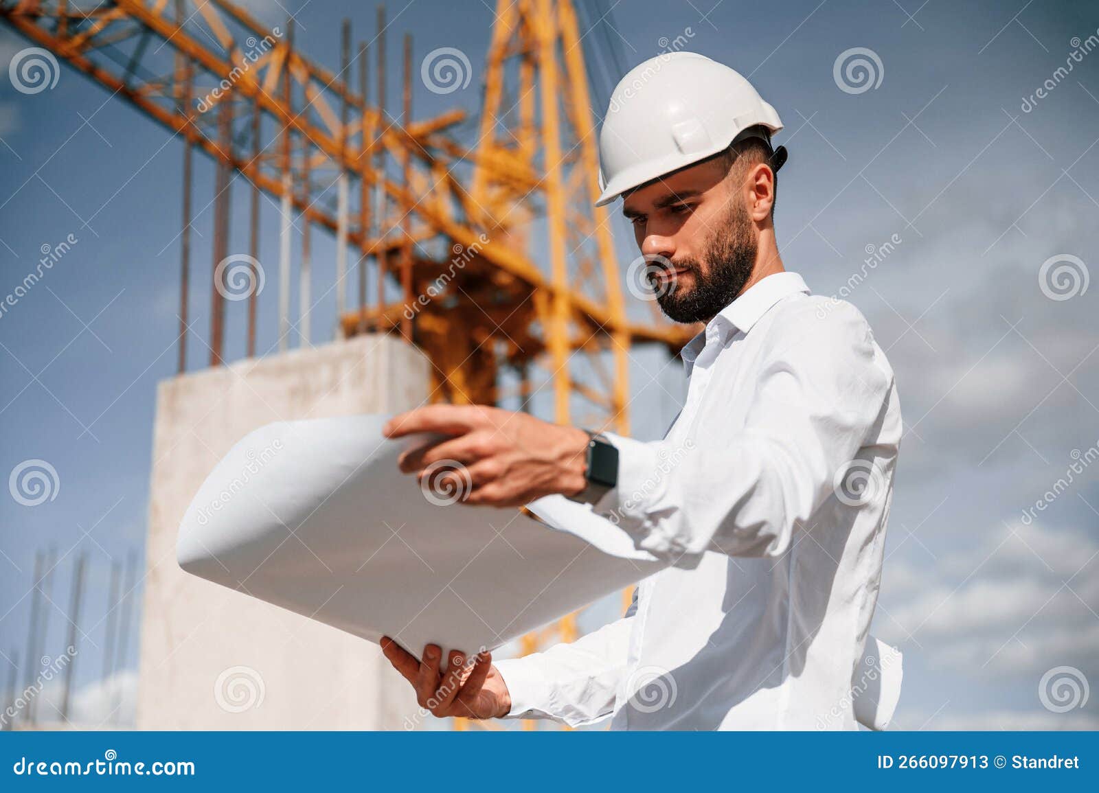 With Plan in Hands. Man in Uniform is Working on the Construction Site ...