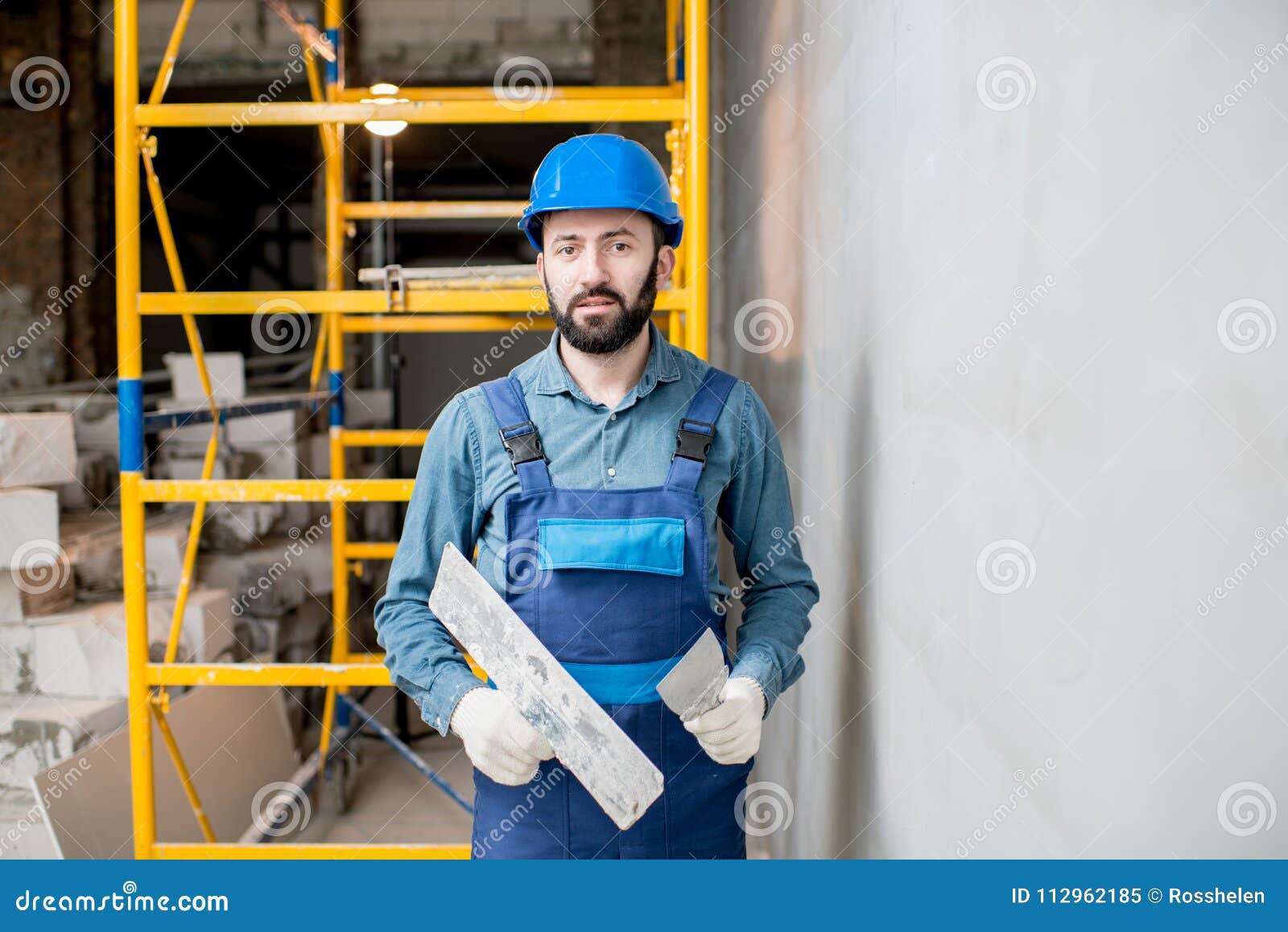 Plasterer working indoors stock image. Image of uniform - 112962185
