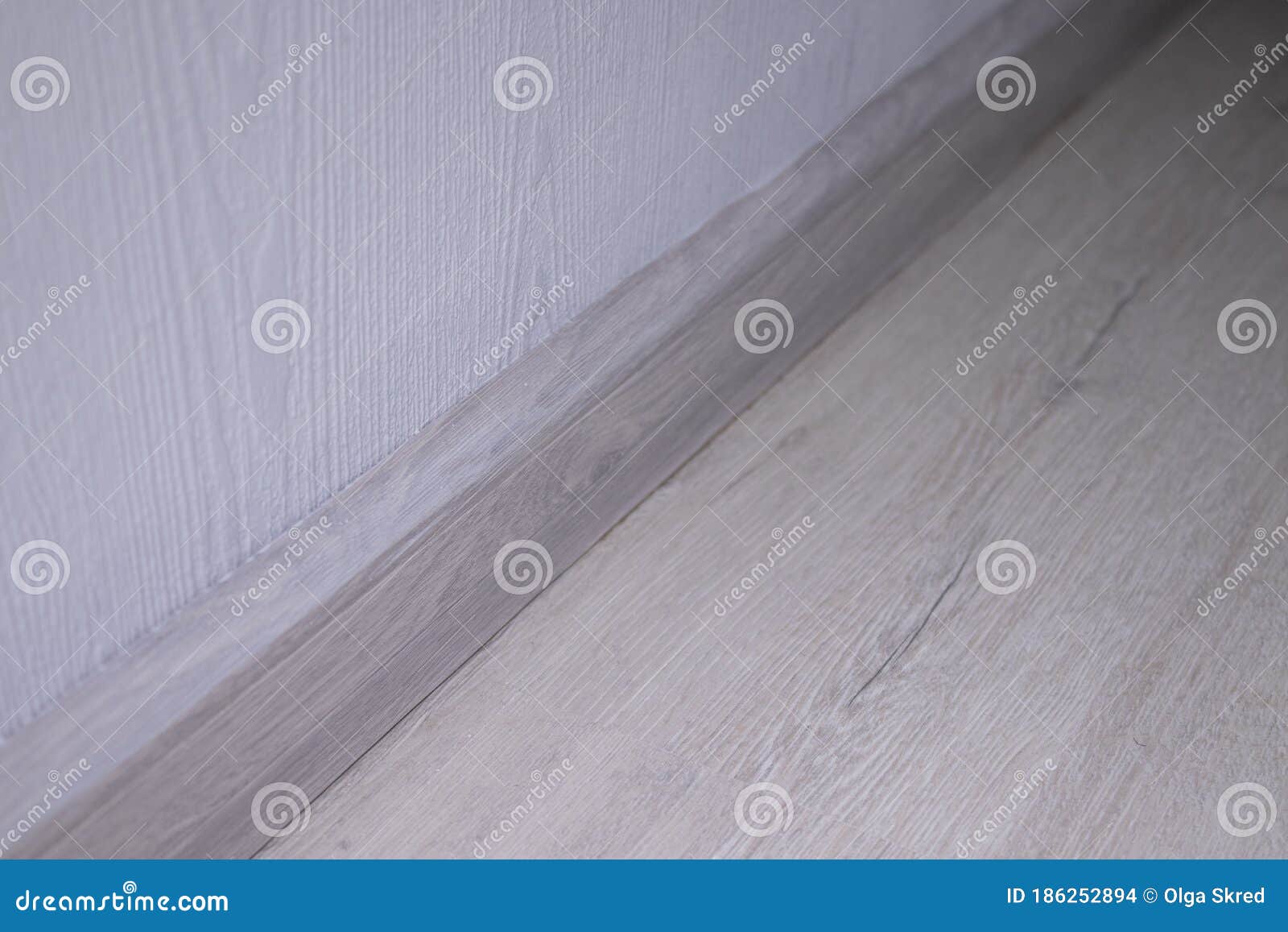 Plastic Baseboard between the Gray Structural Wall and Wood-like ...