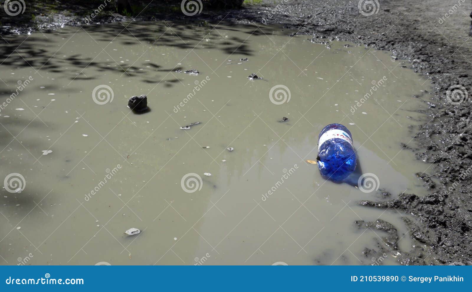 A Plastic Bottle is Lying in a Muddy Puddle. Stock Footage - Video of ...