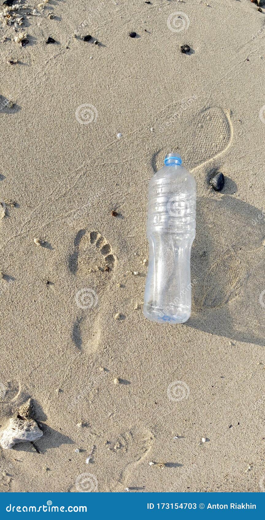 Plastic Bottle in the Sand, Next To the Footprints Stock Image - Image ...