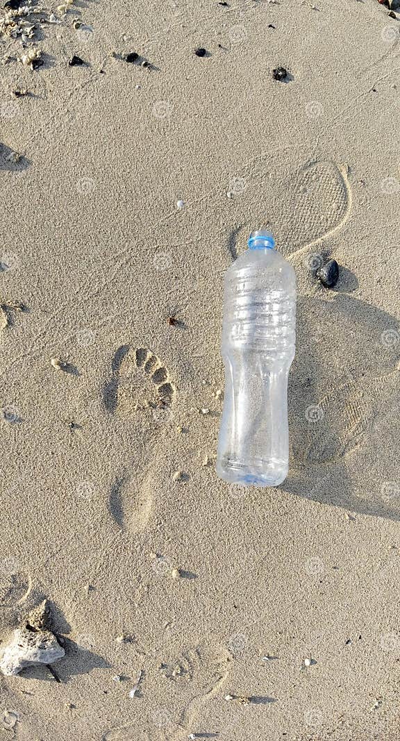 Plastic Bottle in the Sand, Next To the Footprints Stock Image - Image ...