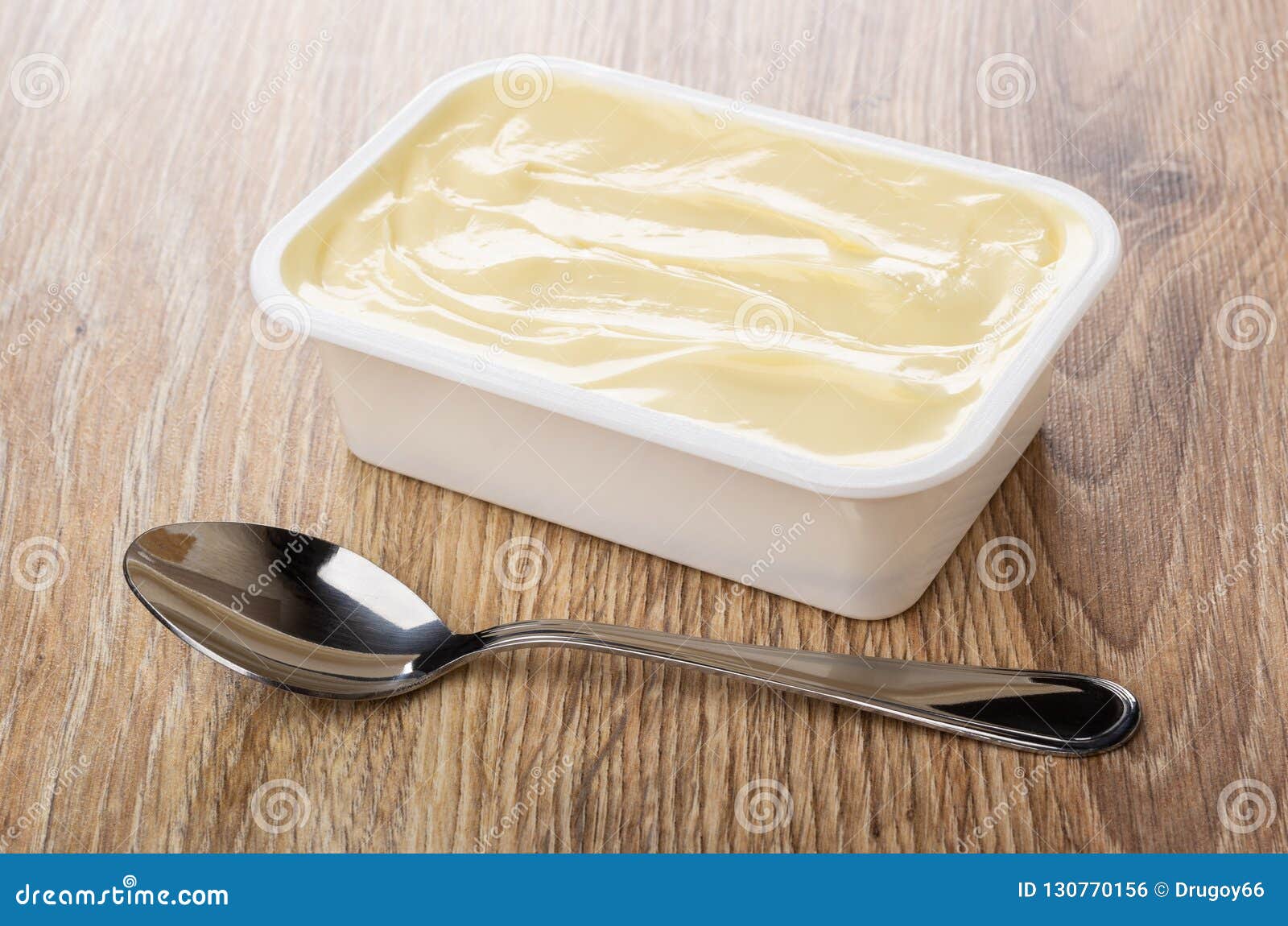 Plastic Container with Melted Cheese, Spoon on Table Stock Photo ...