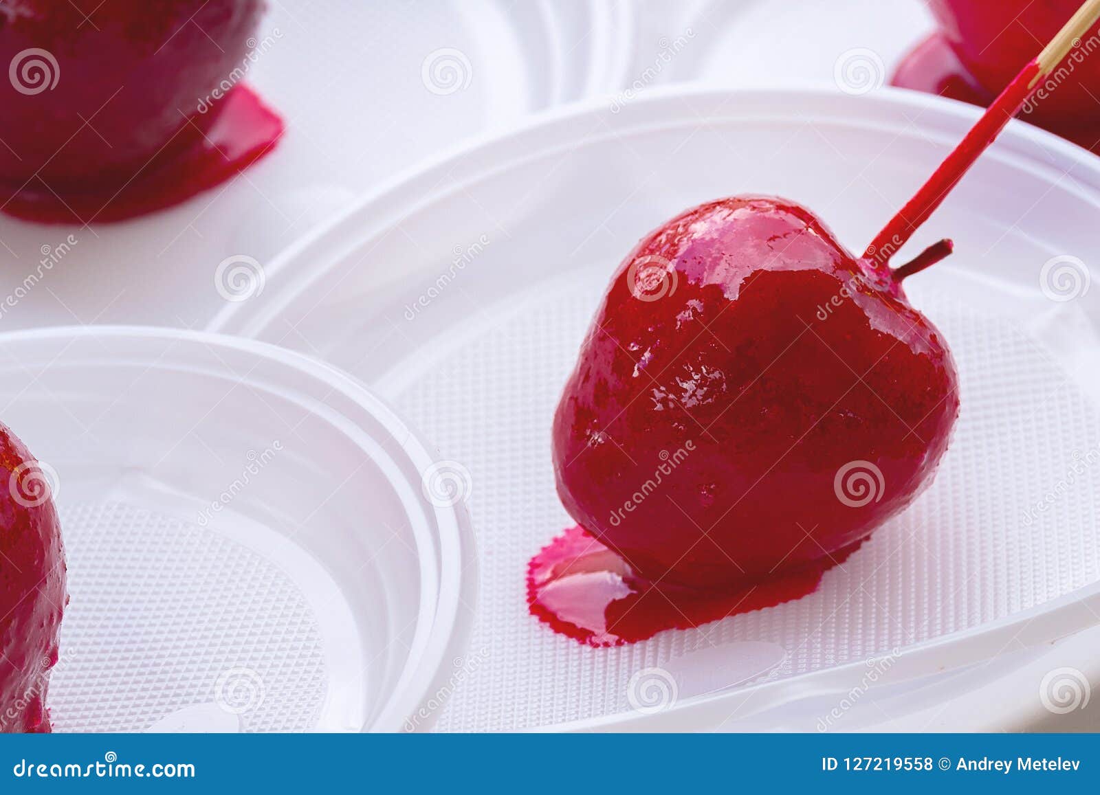 On a Plastic Disposable Plate are Apples Drenched in Red Caramel, Baked ...
