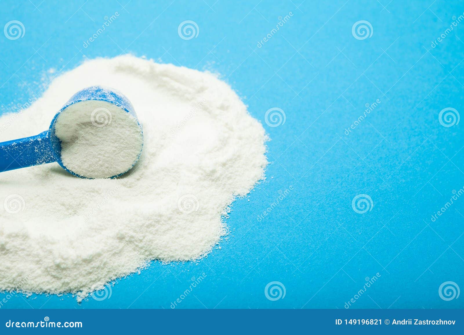 Plastic Spoon with Milk Powder on a Blue Background, Empty Space for ...